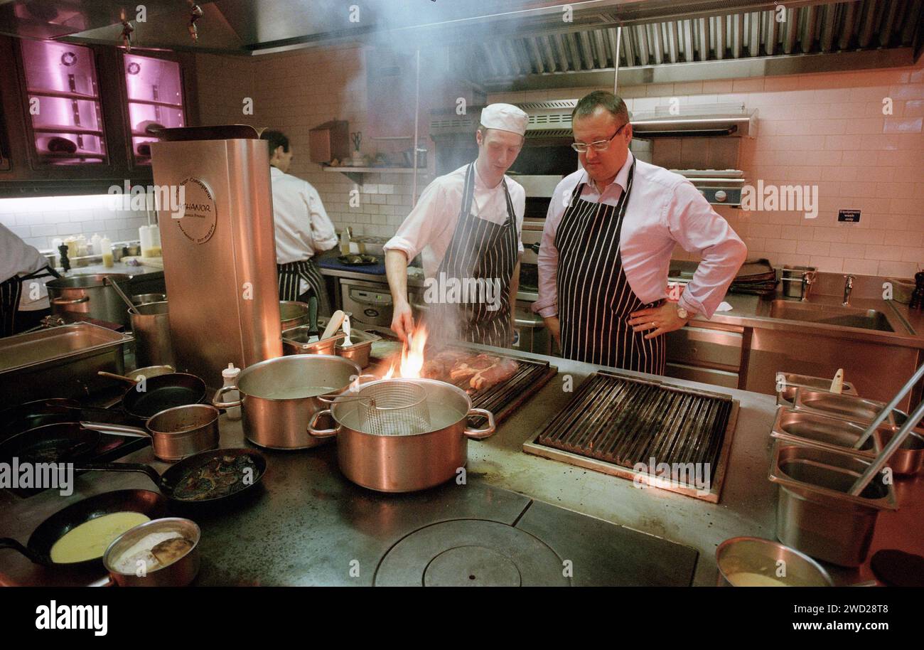 Chefs preparing steaks in an open to view kitchen for the customers at ...