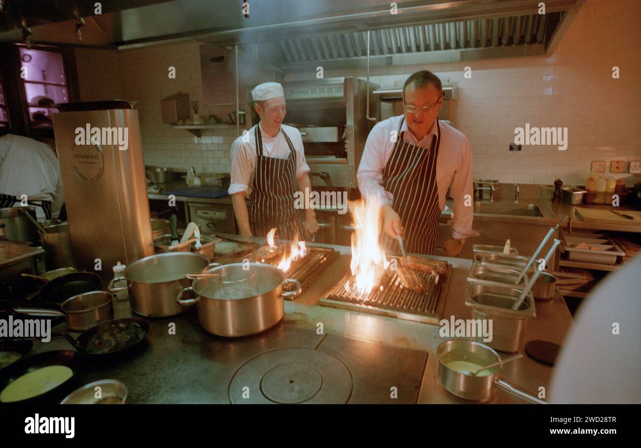 Chefs preparing steaks in an open to view kitchen for the customers at ...