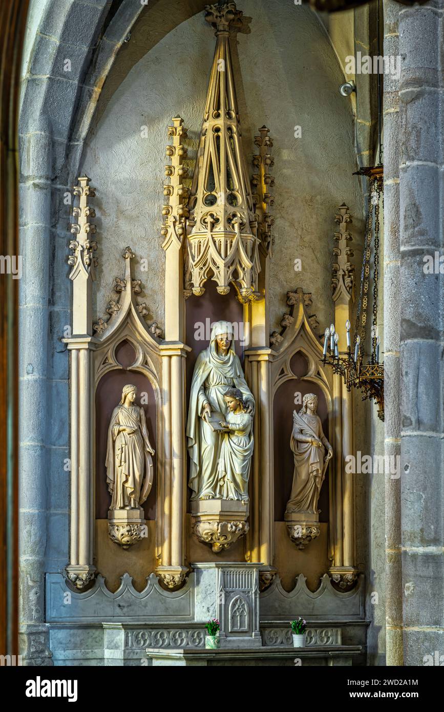 Madonna with child and statues of saints in a niche with Gothic style ...