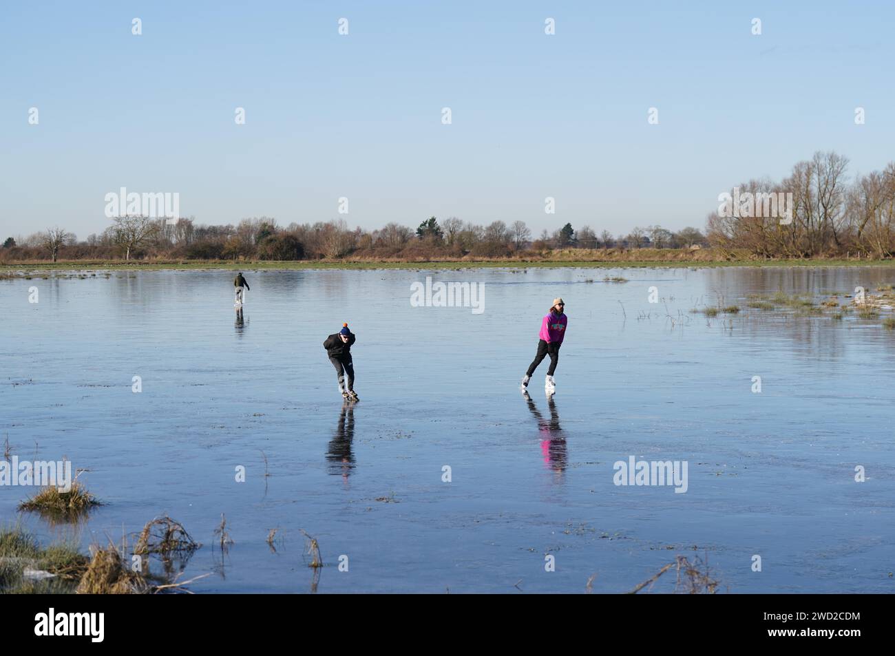 Fen skaters on a frozen flooded field in Upware, Cambridgeshire. The UK ...