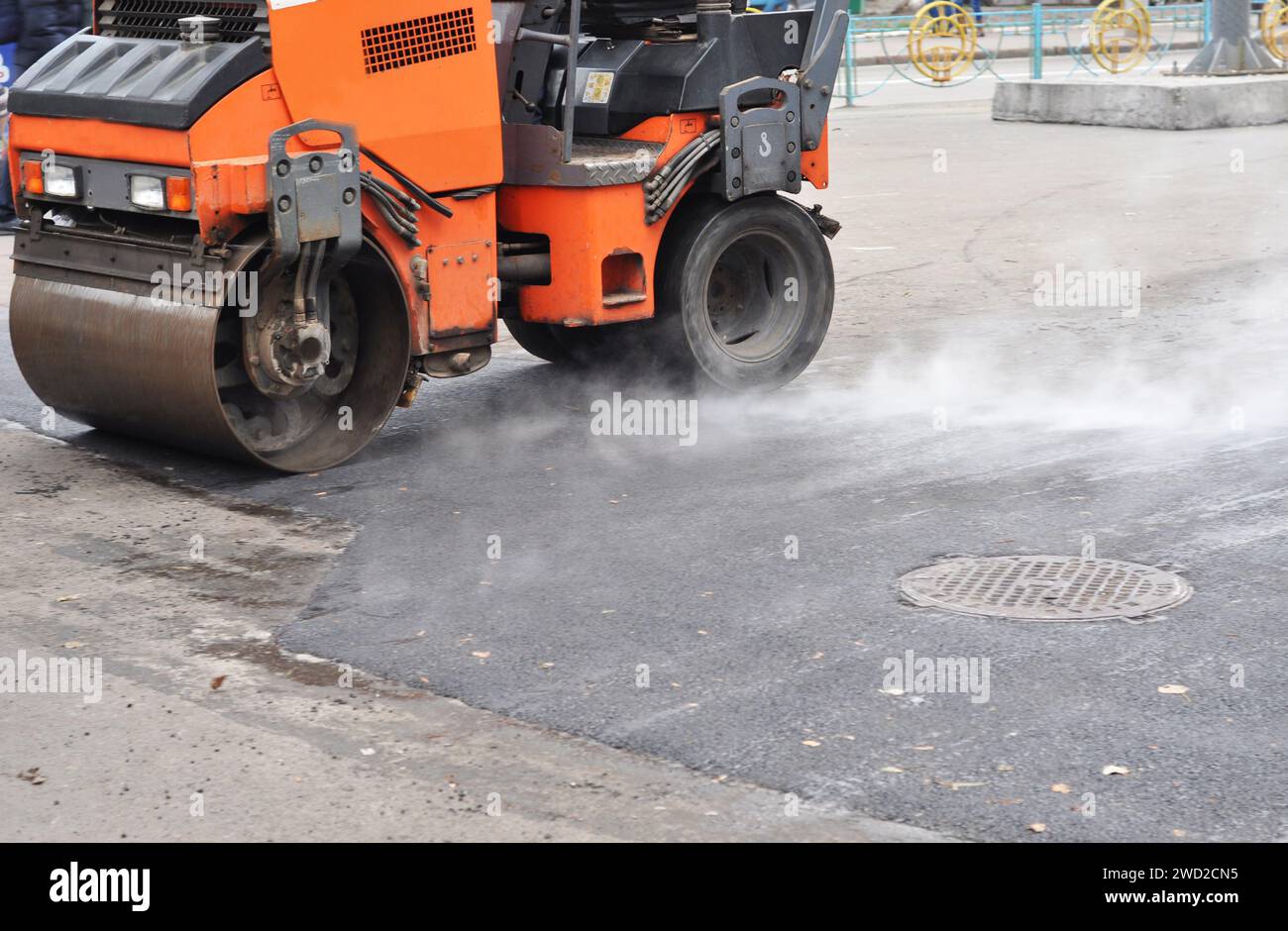 The road roller or steam roller is compacting, paving hot asphalt ...