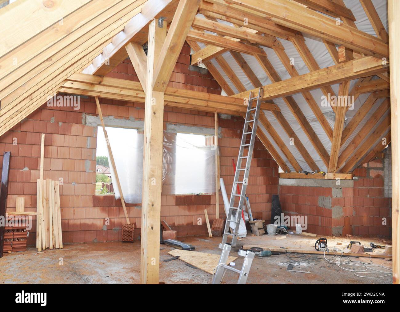 Incomplete attic with roof trusses, wooden roof beams, braces and ...