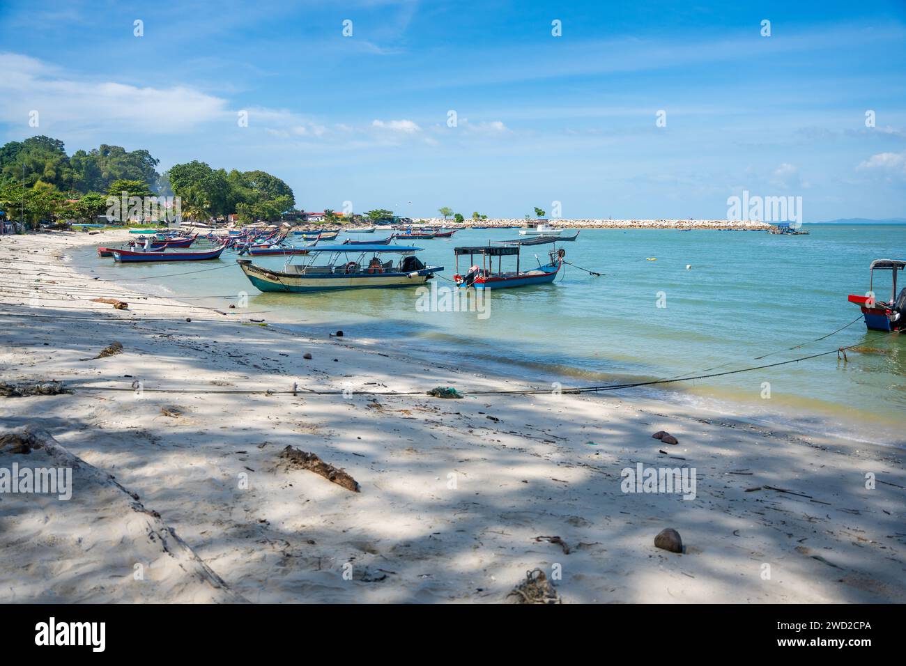 Fishing boats on the sea and beach of George Town city in the distance ...