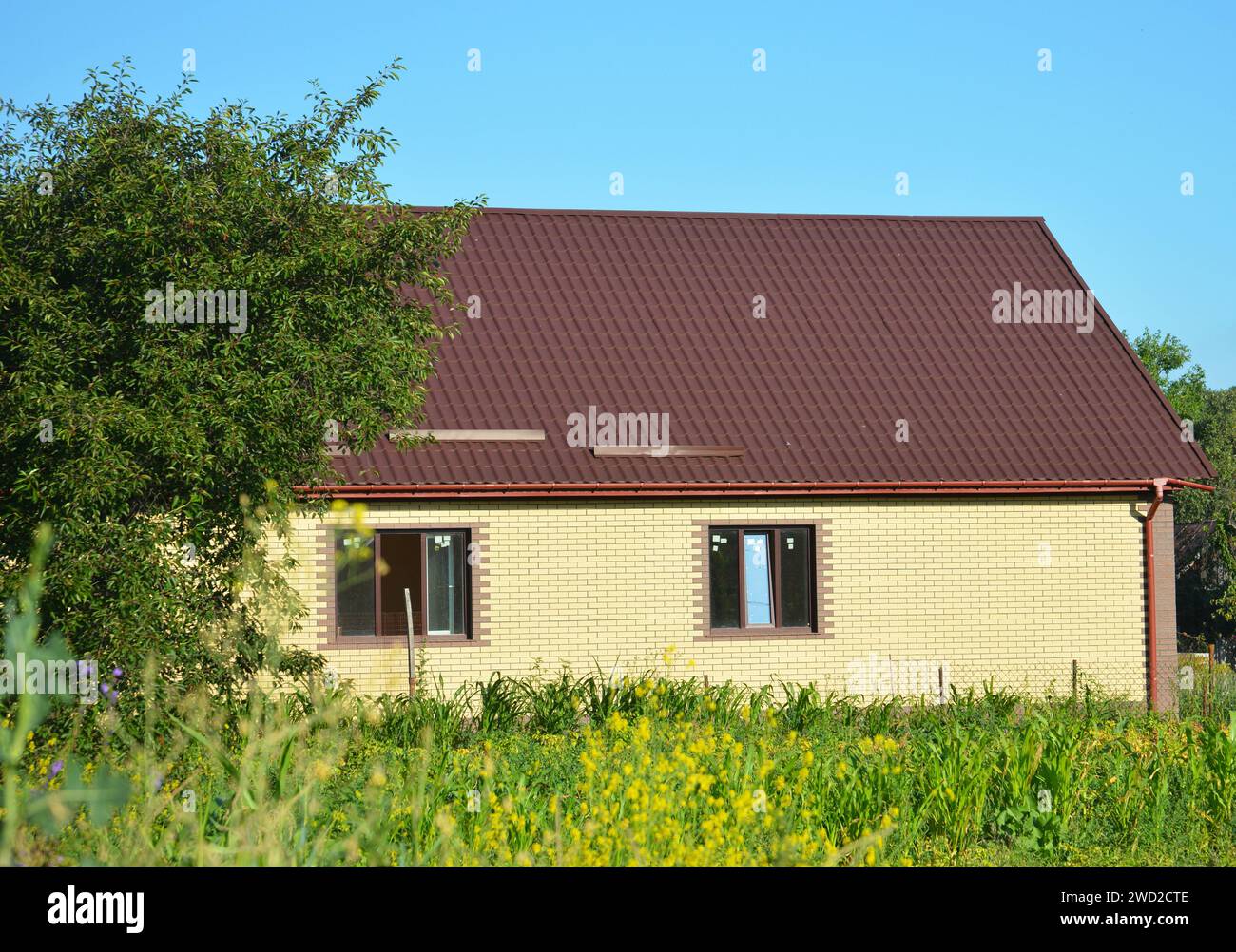 A picturesque view of a small brick house of simple construction with ...