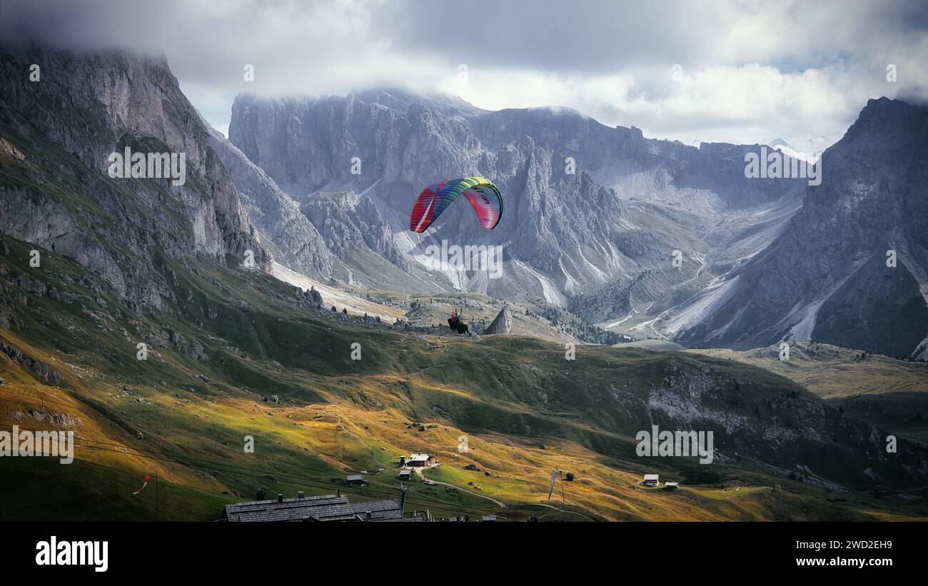 Paraglider in flight on the side of Mount Seceda in Dolomites, Italy ...