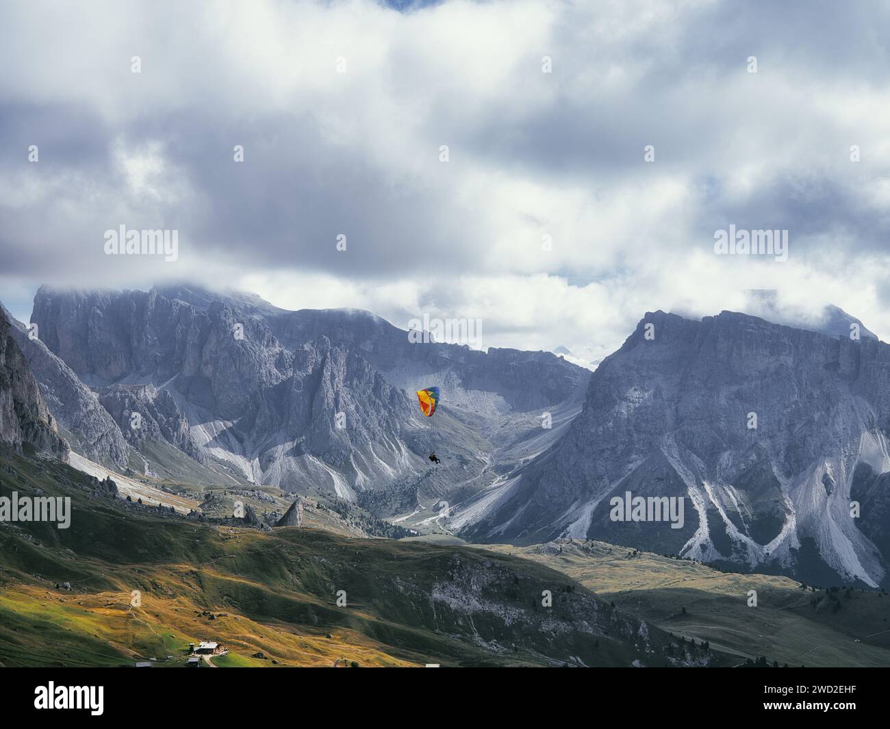 Paraglider in flight on the side of Mount Seceda in Dolomites, Italy ...