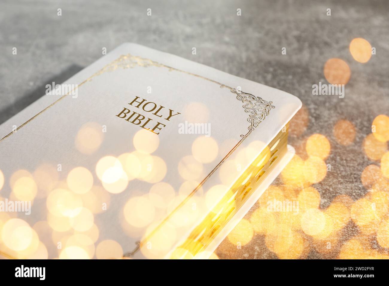 Holy Bible on stone table, bokeh effect Stock Photo - Alamy