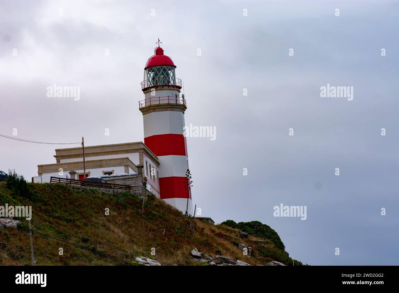 The Cabo Silleiro lighthouse with its red stripes on the rocky mountain ...