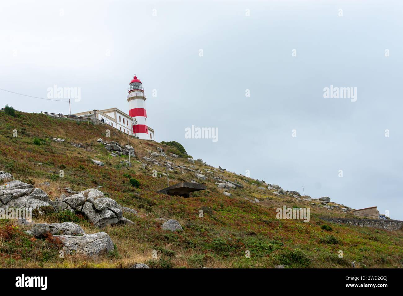 The Cabo Silleiro lighthouse with its red stripes on the rocky mountain ...