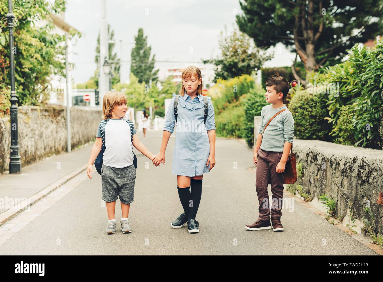 Cute kids with backpacks walking back to school Stock Photo - Alamy