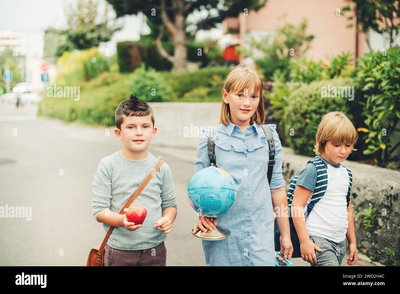 Group of three funny kids wearing backpacks walking back to school ...