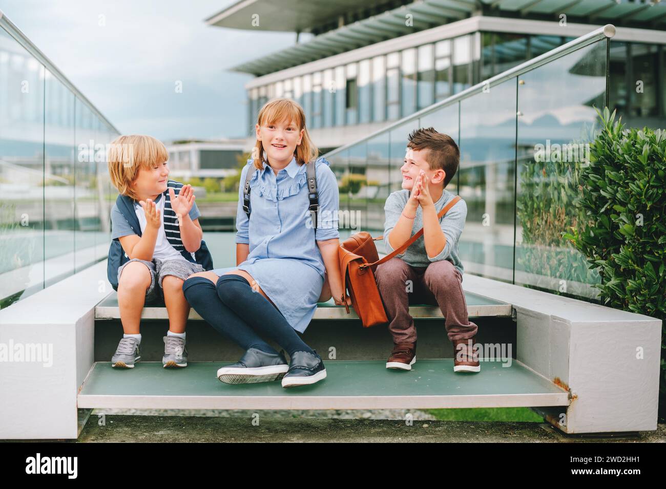 Group of 3 funny schoolkids posing outdoors, wearing backpacks. Back to ...