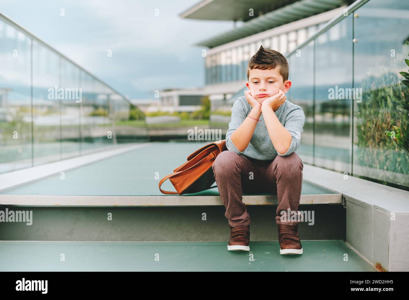 Sad kid boy resting outdoors. Bored little student Stock Photo - Alamy