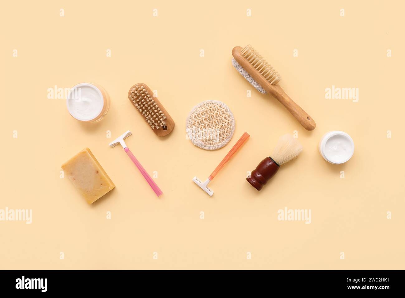 Safety razors with brushes, soap and jars of cream on beige background ...