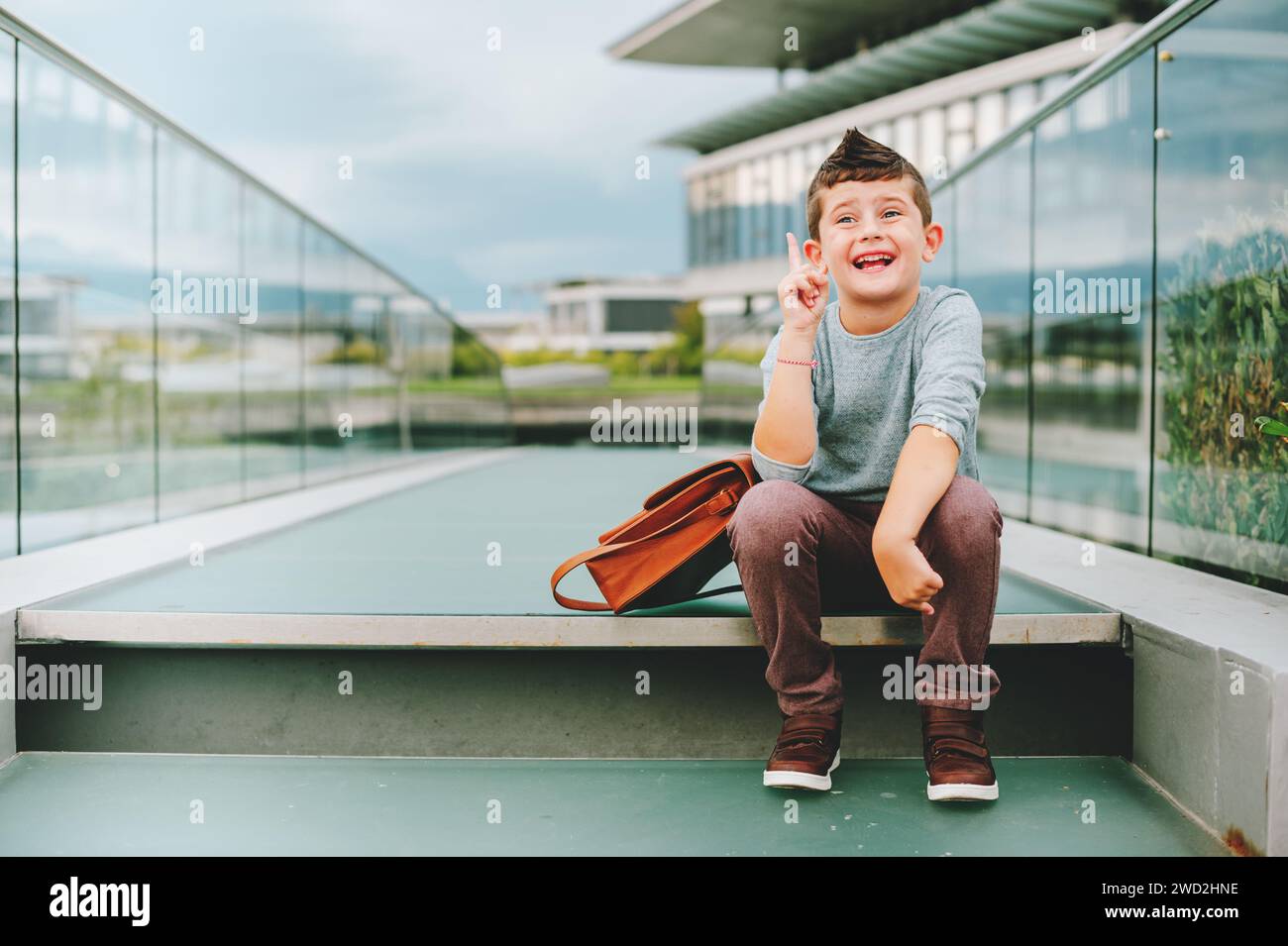 Outdoor portrait of happy young kid boy. Fashion schoolboy resting ...