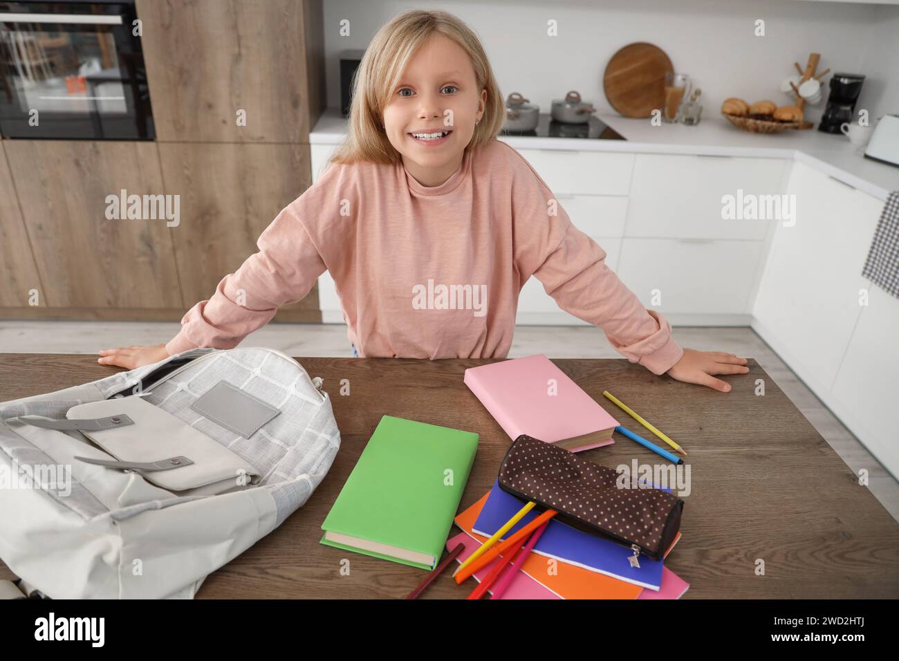 Little schoolgirl unpacking backpack in kitchen Stock Photo - Alamy
