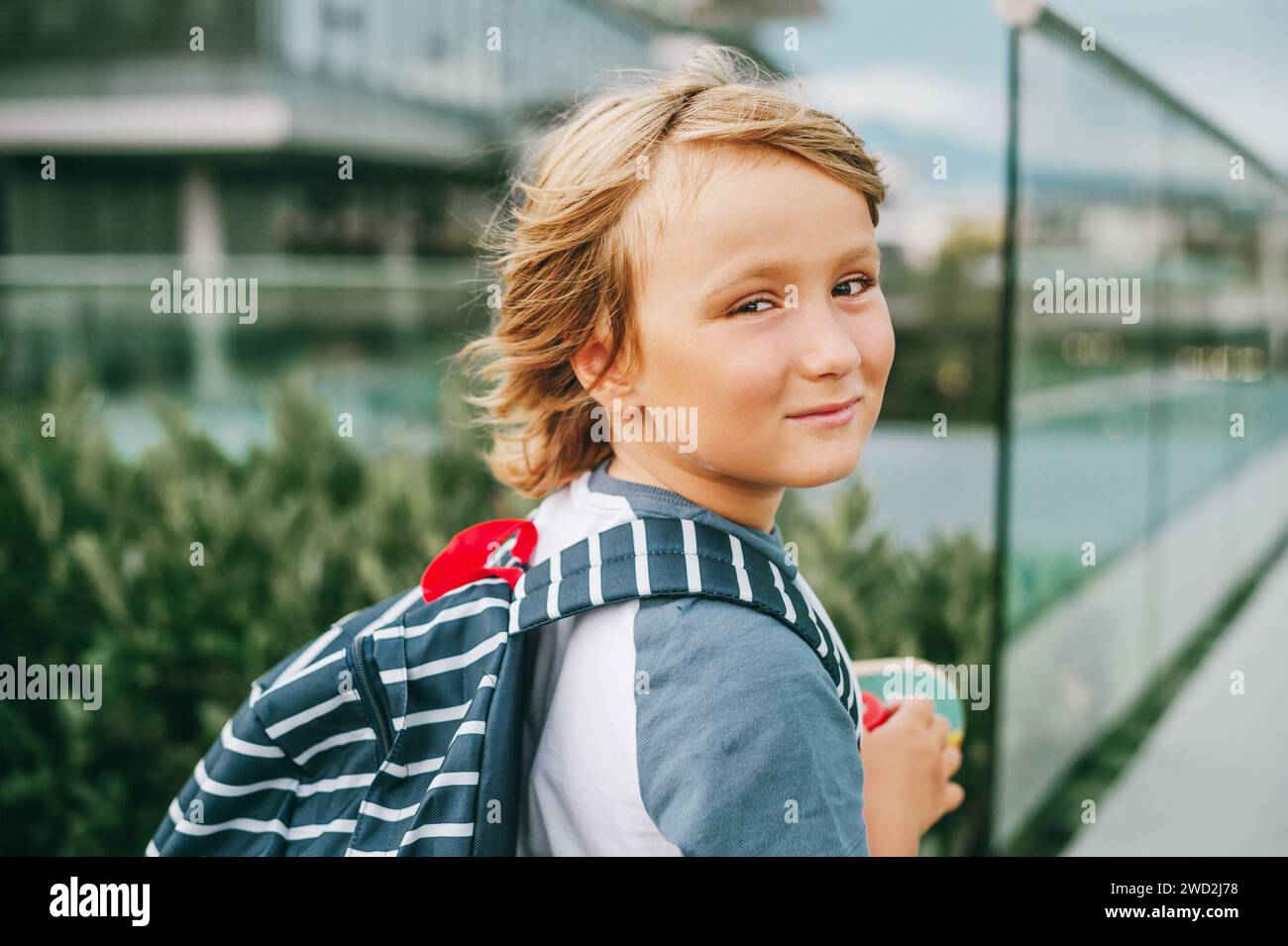 Close up portrait of young cute little 6 year old boy wearing backpack ...
