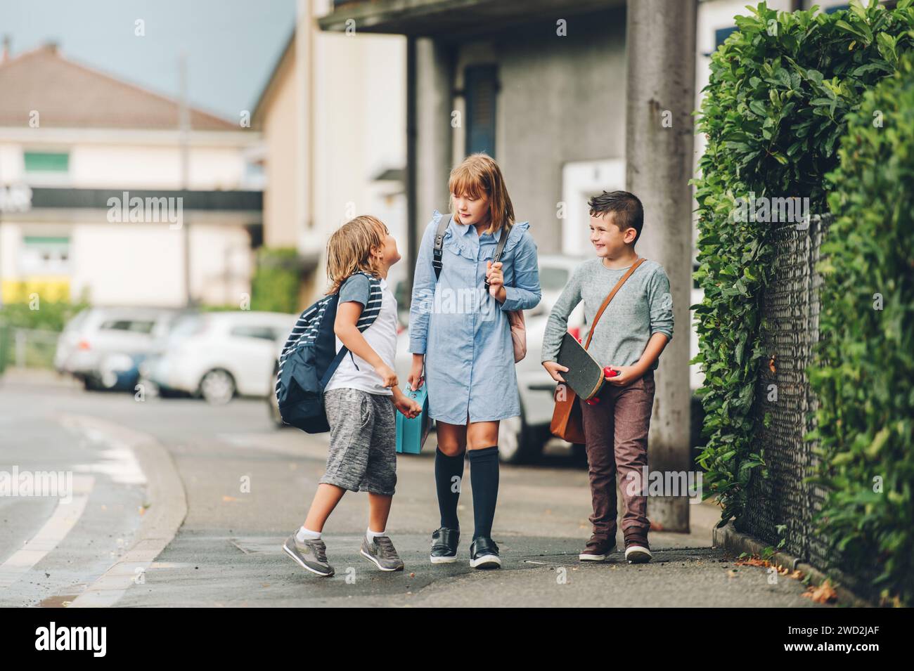 Group of 3 funny schoolkids walking back to school together, wearing ...