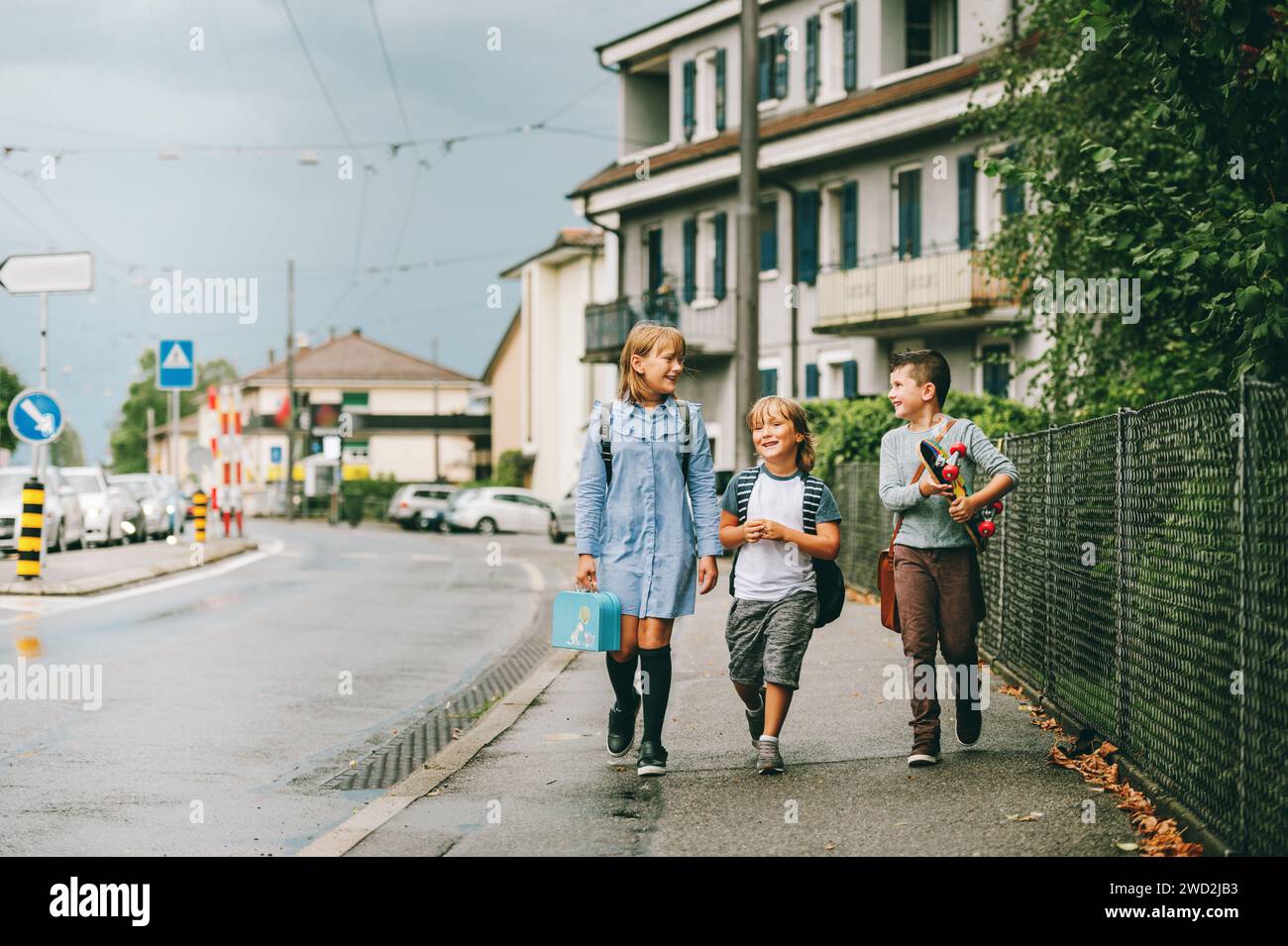 Group of 3 funny schoolkids walking back to school together, wearing ...