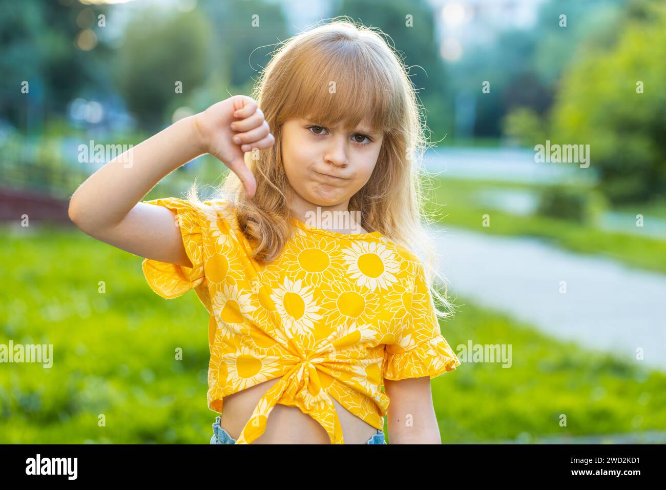 Dislike. Upset preteen child kid showing thumbs down sign gesture ...