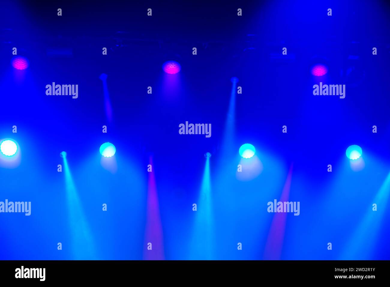 Blue stage lighting with white light beams from laser spotlights Stock ...