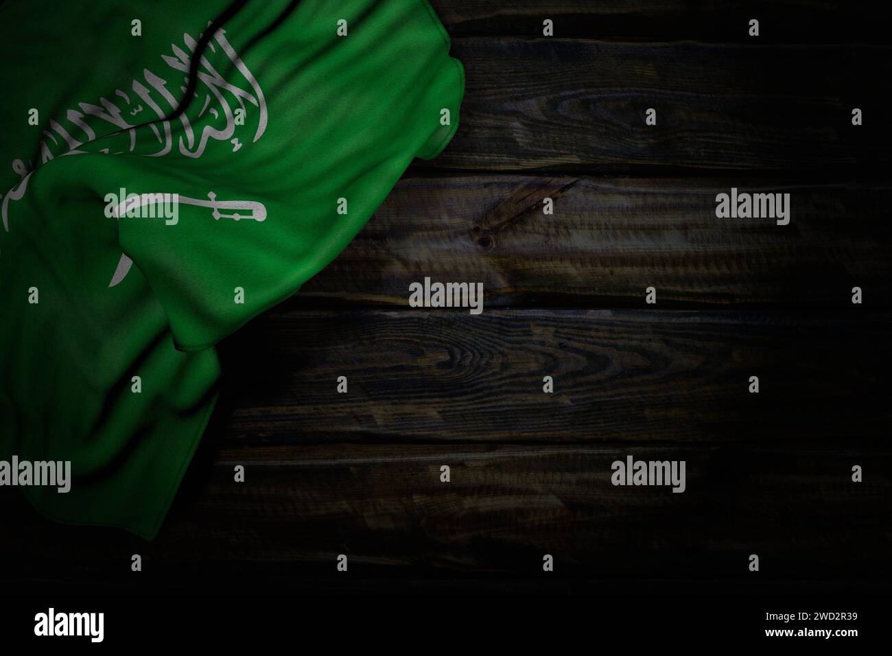 nice dark photo of Saudi Arabia flag with big folds on old wood with ...