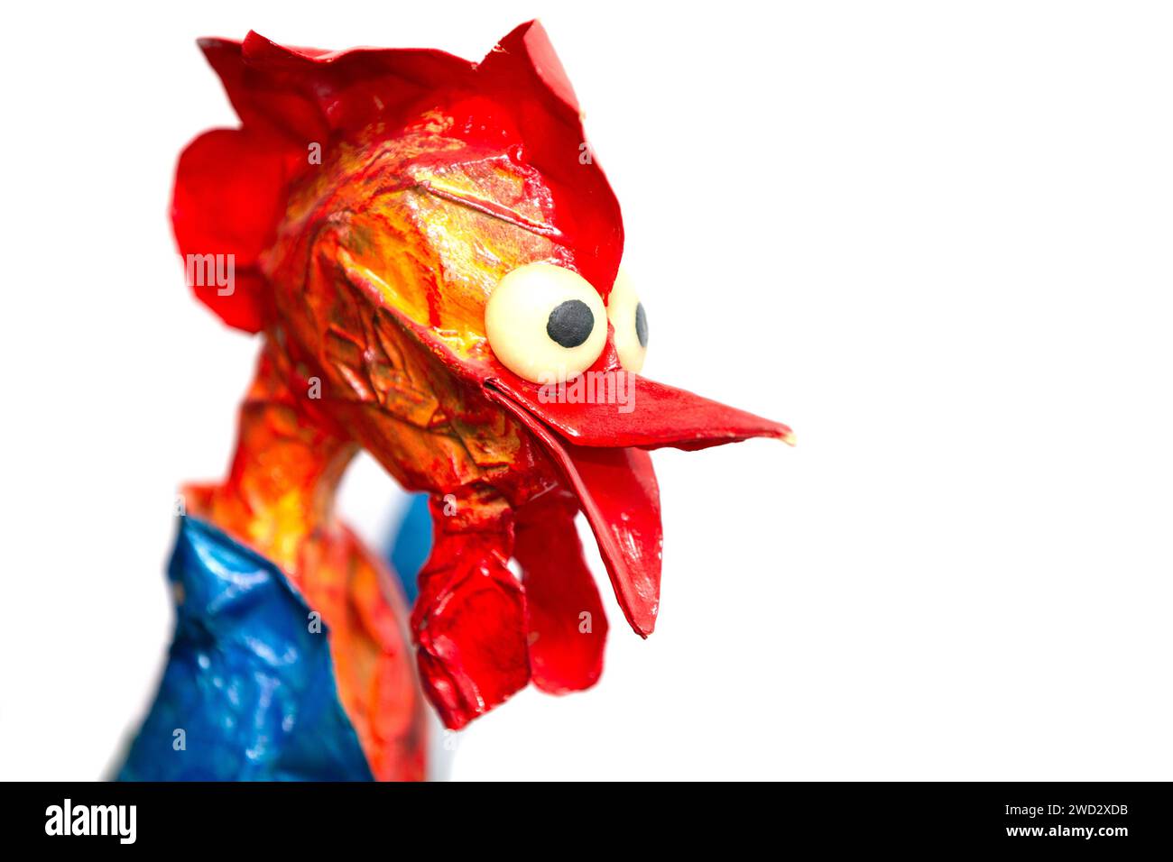 The muzzle of a funny fairy-tale rooster made of papier mache on a ...