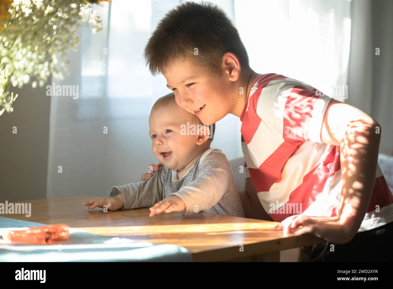 Older brother kissing and hugging his baby boy. Two siblings. Beautiful ...
