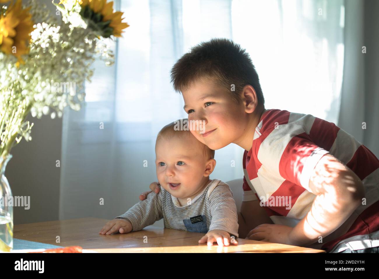 Older brother kissing and hugging his baby boy. Two siblings. Beautiful ...