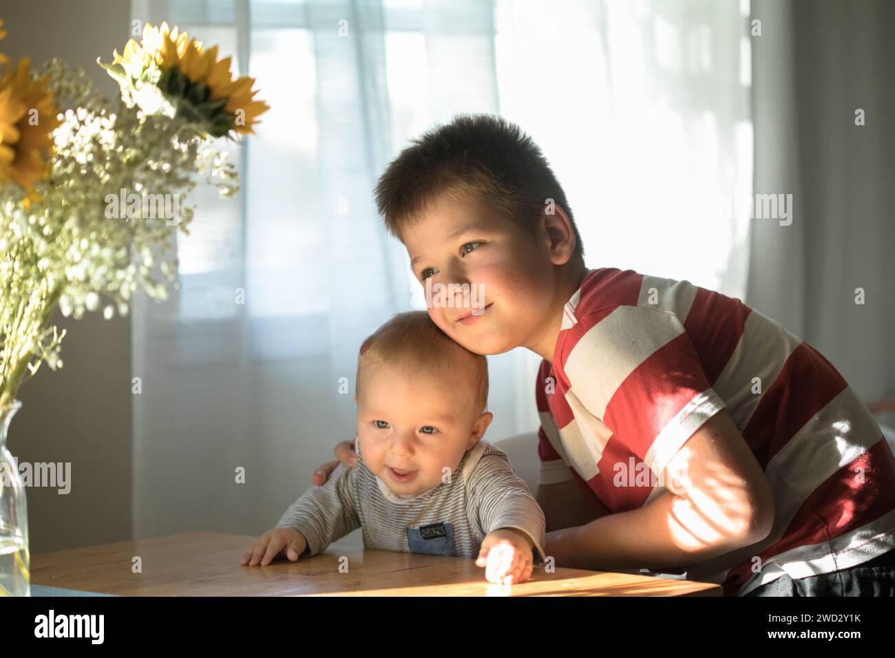 Older brother kissing and hugging his baby boy. Two siblings. Beautiful ...