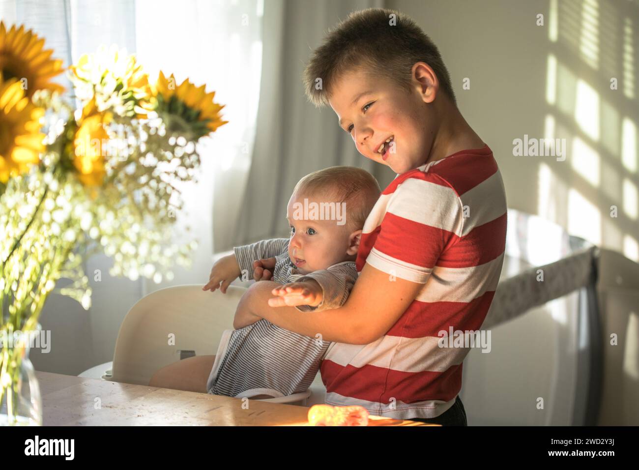 Older brother kissing and hugging his baby boy. Two siblings. Beautiful ...