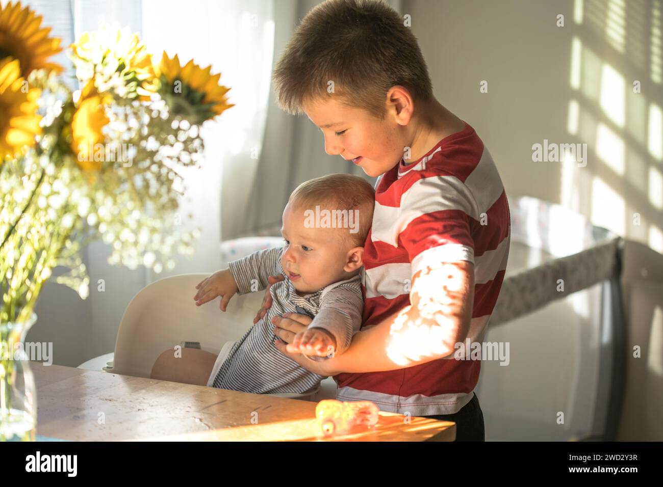 Older brother kissing and hugging his baby boy. Two siblings. Beautiful ...