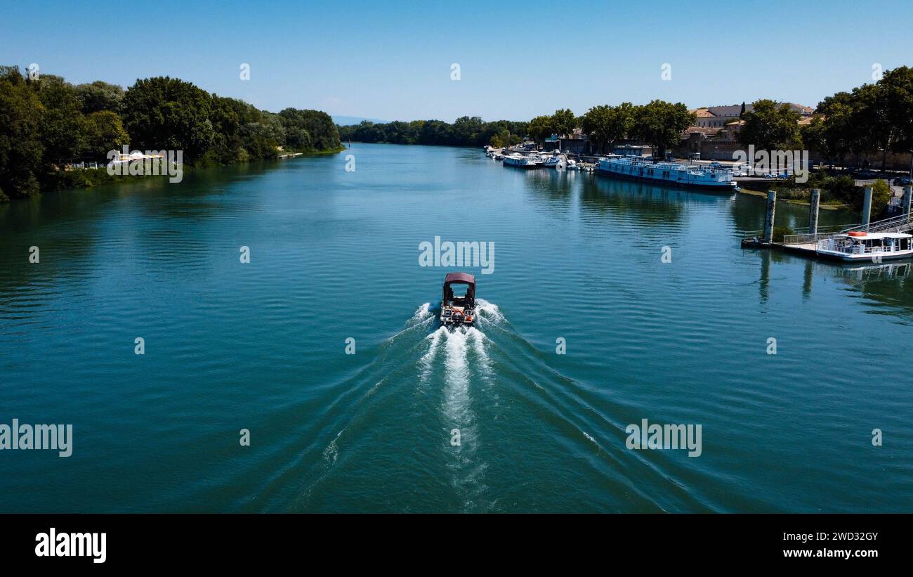 Romantic image with boat in the Rhone river passing through the city of ...