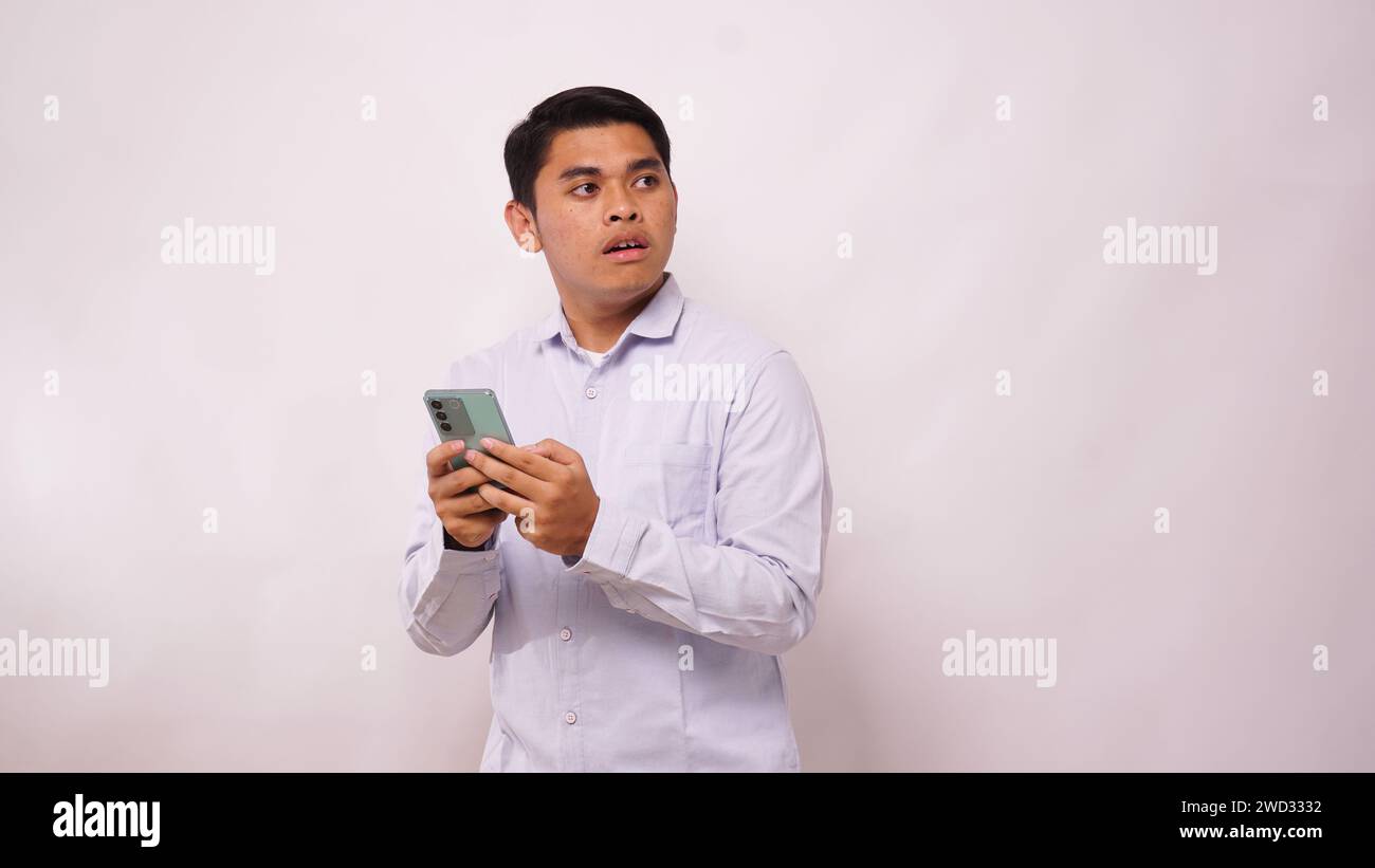 Asian man scratch his head while holding mobile phone and showing ...