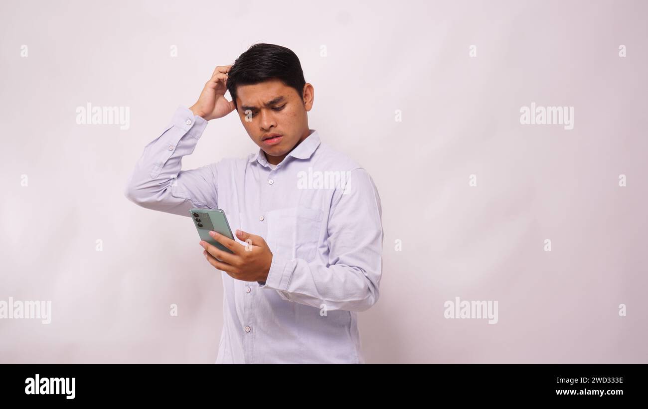 Asian man scratch his head while holding mobile phone and showing ...