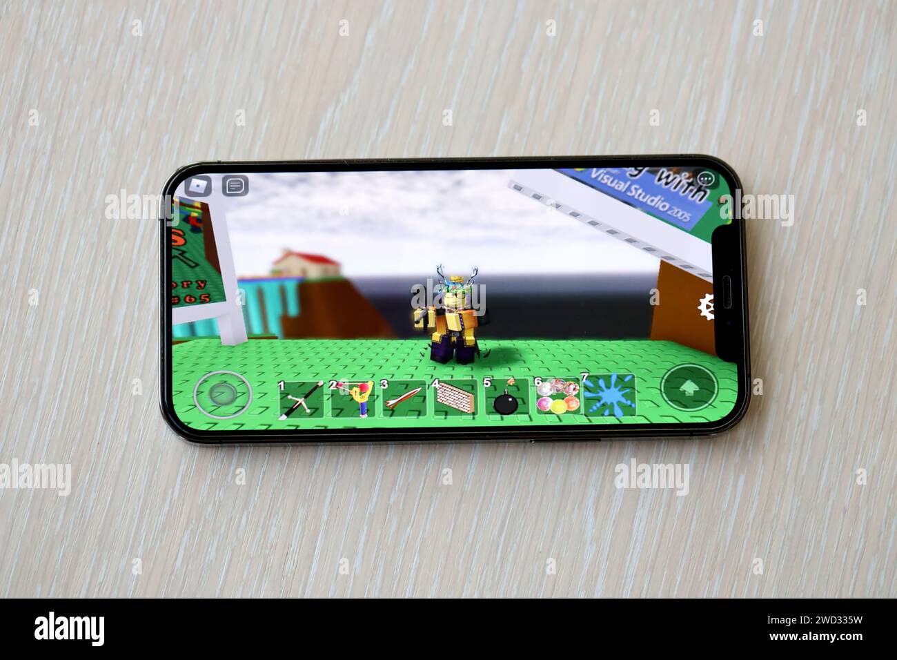 Roblox mobile iOS game on iPhone 15 smartphone screen on wooden table ...