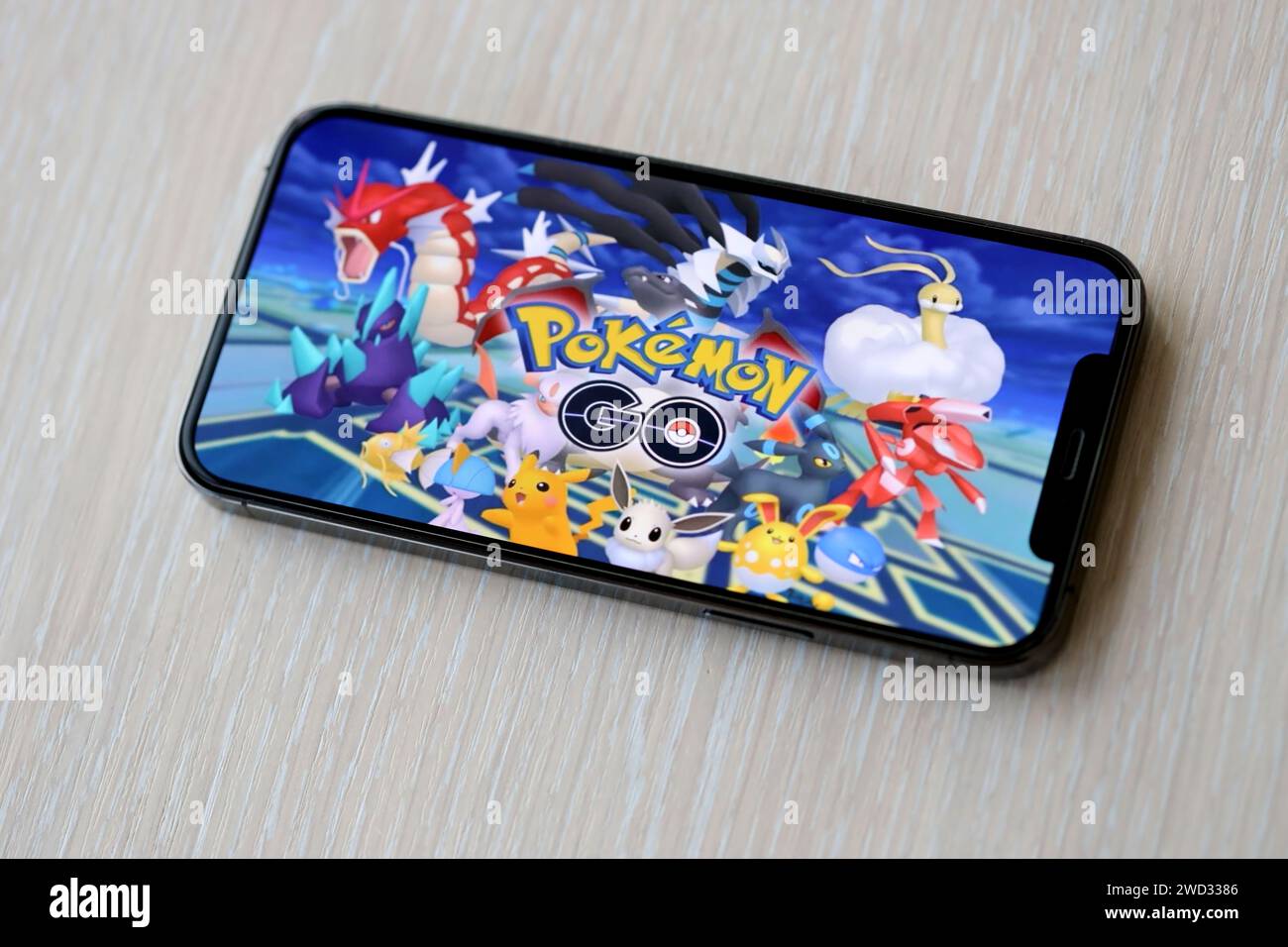 Pokemon GO mobile iOS game on iPhone 15 smartphone screen on wooden ...