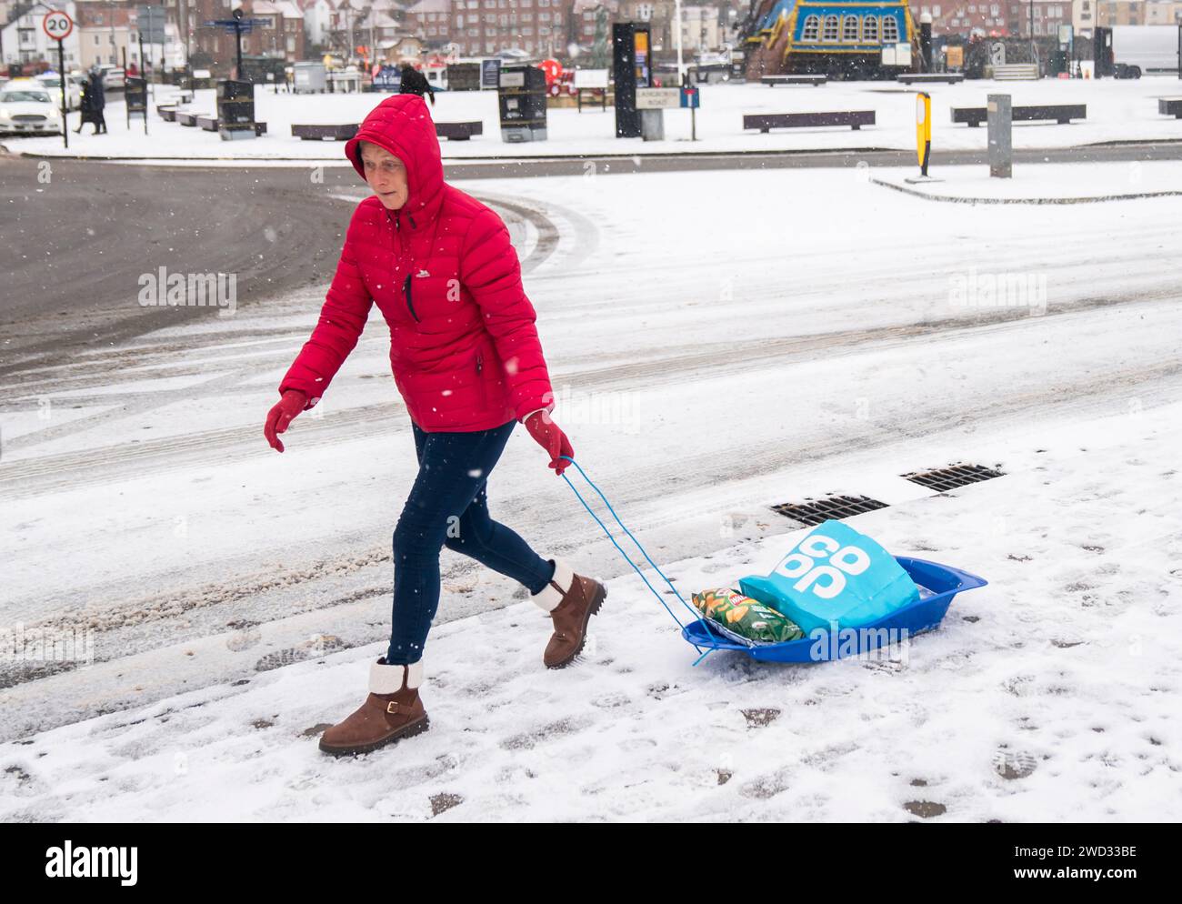 A person pulls a sled through snow in Whitby. Hundreds of schools are ...