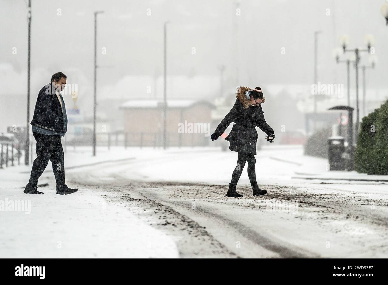 People make their way through snow in Whitby. Hundreds of schools are ...