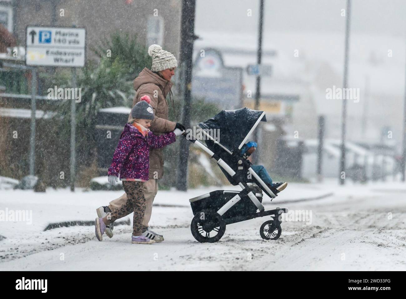 People make their way through snow in Whitby. Hundreds of schools are ...