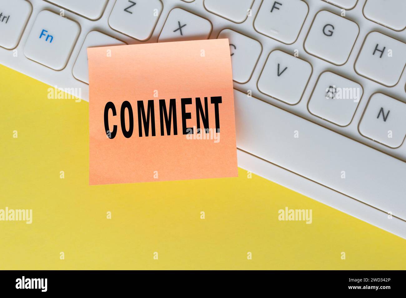 Comment text on orange sticky note on top of white keyboard Stock Photo ...