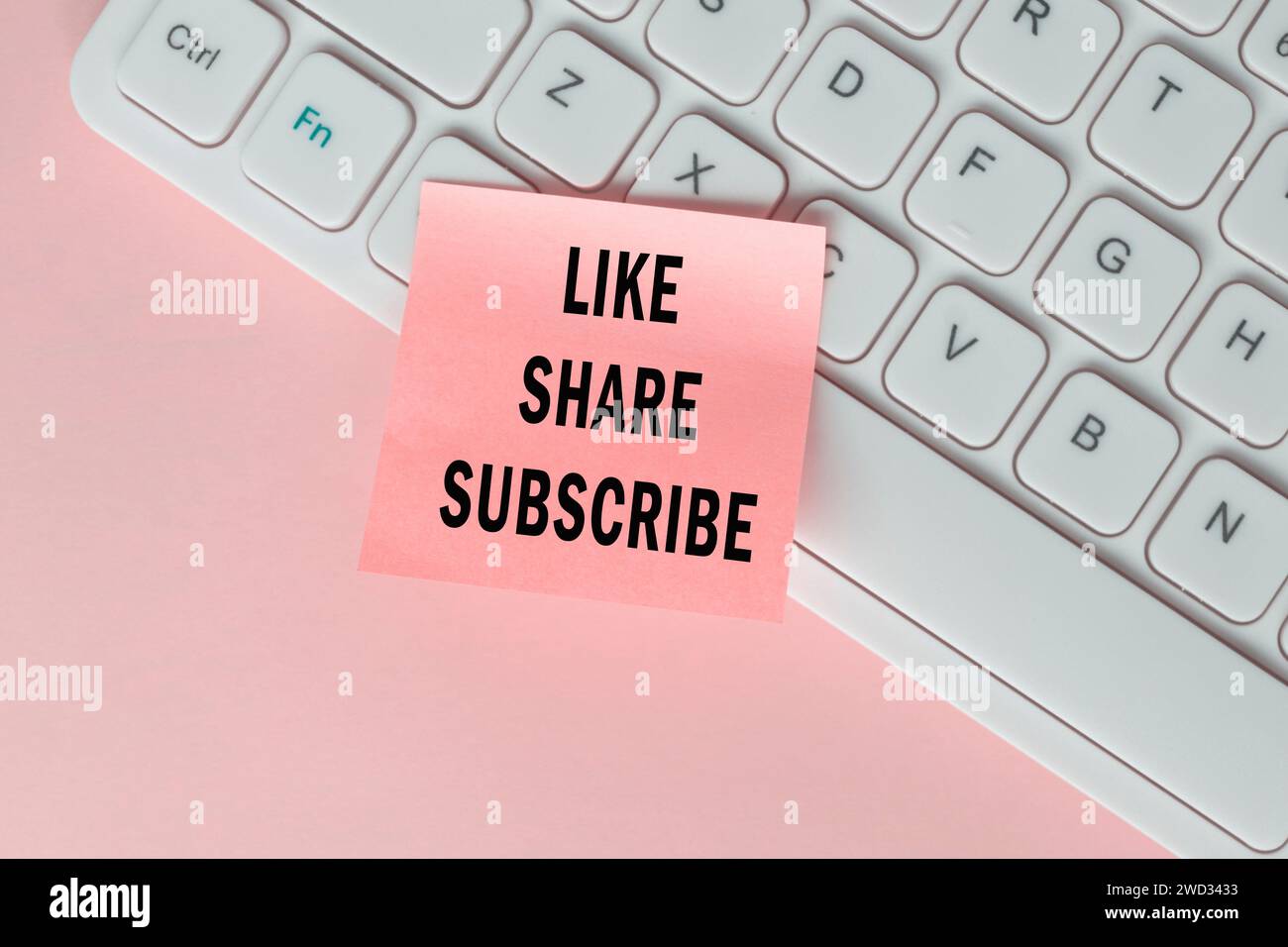 Like Share Subscribe text on orange sticky note on top of white ...