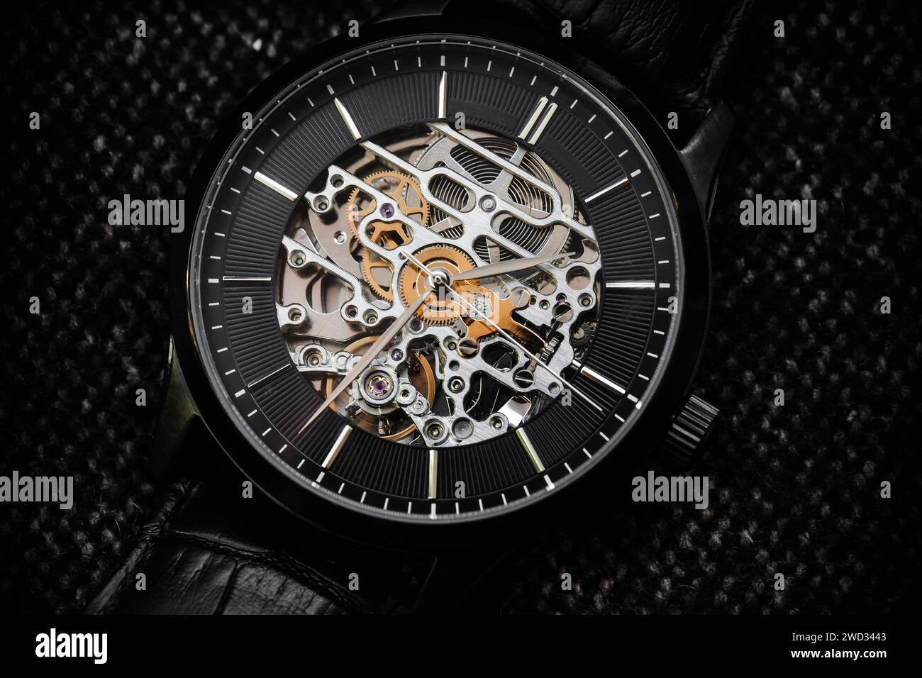 Black clock face with metal details of mechanic skeleton watch, close ...