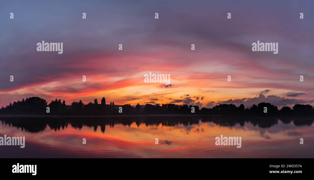 Dramatic sunset sky above the lake water surface with beautiful ...