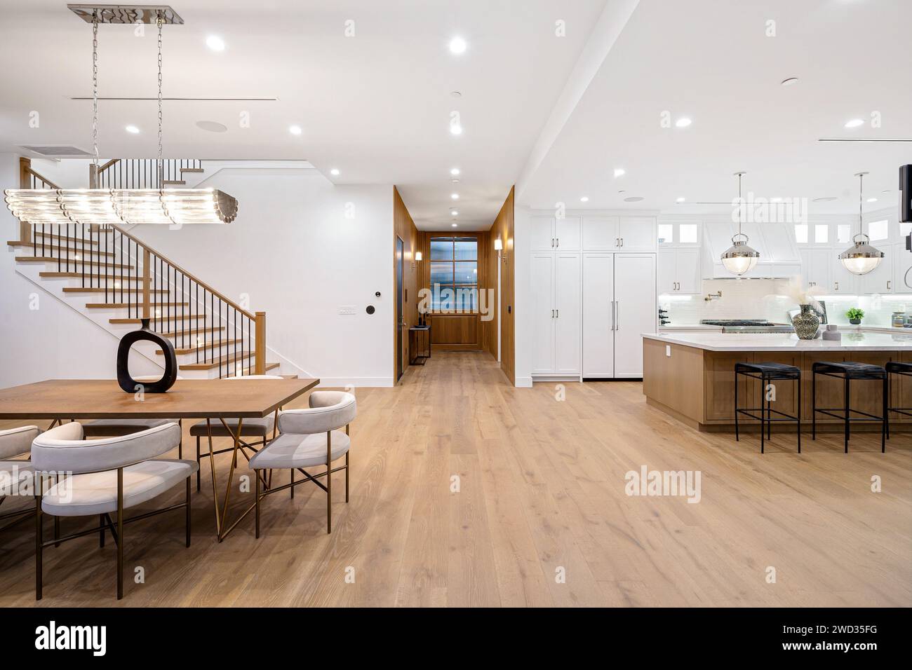Empty kitchen with tables, chairs, and staircase Stock Photo - Alamy
