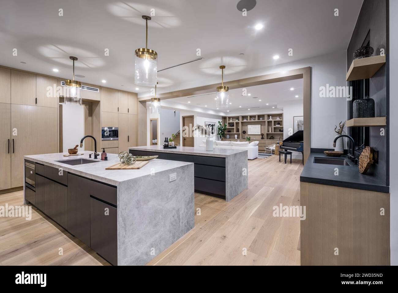Open kitchen with white and black countertops and sleek dark cupboards ...