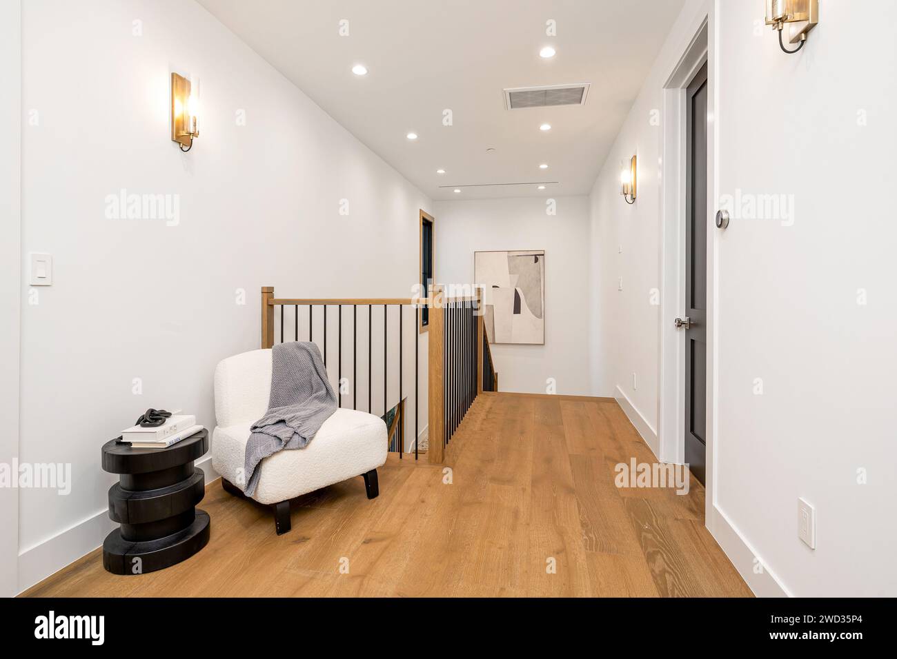 A narrow and well-lit hallway with gleaming hardwood floors Stock Photo ...
