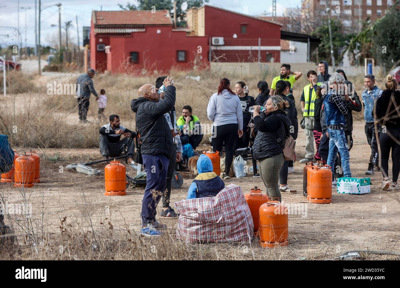 Several people look at smoke at the site of a fire, January 18, 2024 ...