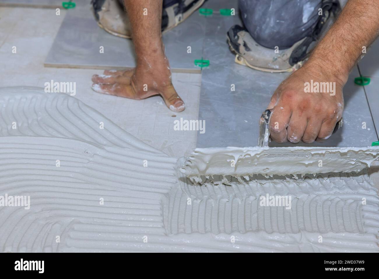 Tiler applies adhesive floor install hi-res stock photography and ...
