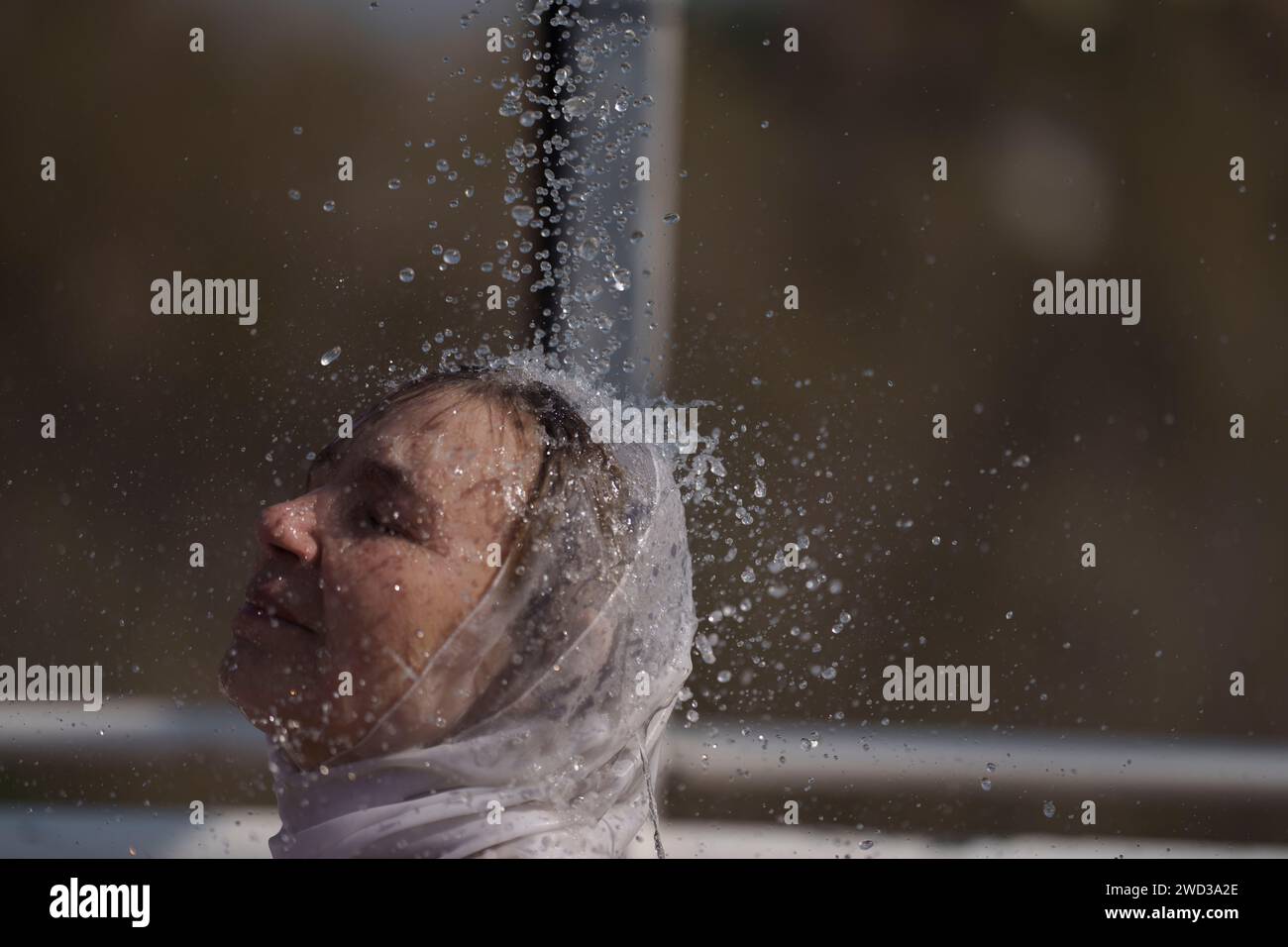 Greek Orthodox pilgrim bathes in water from the Jordan River that ...